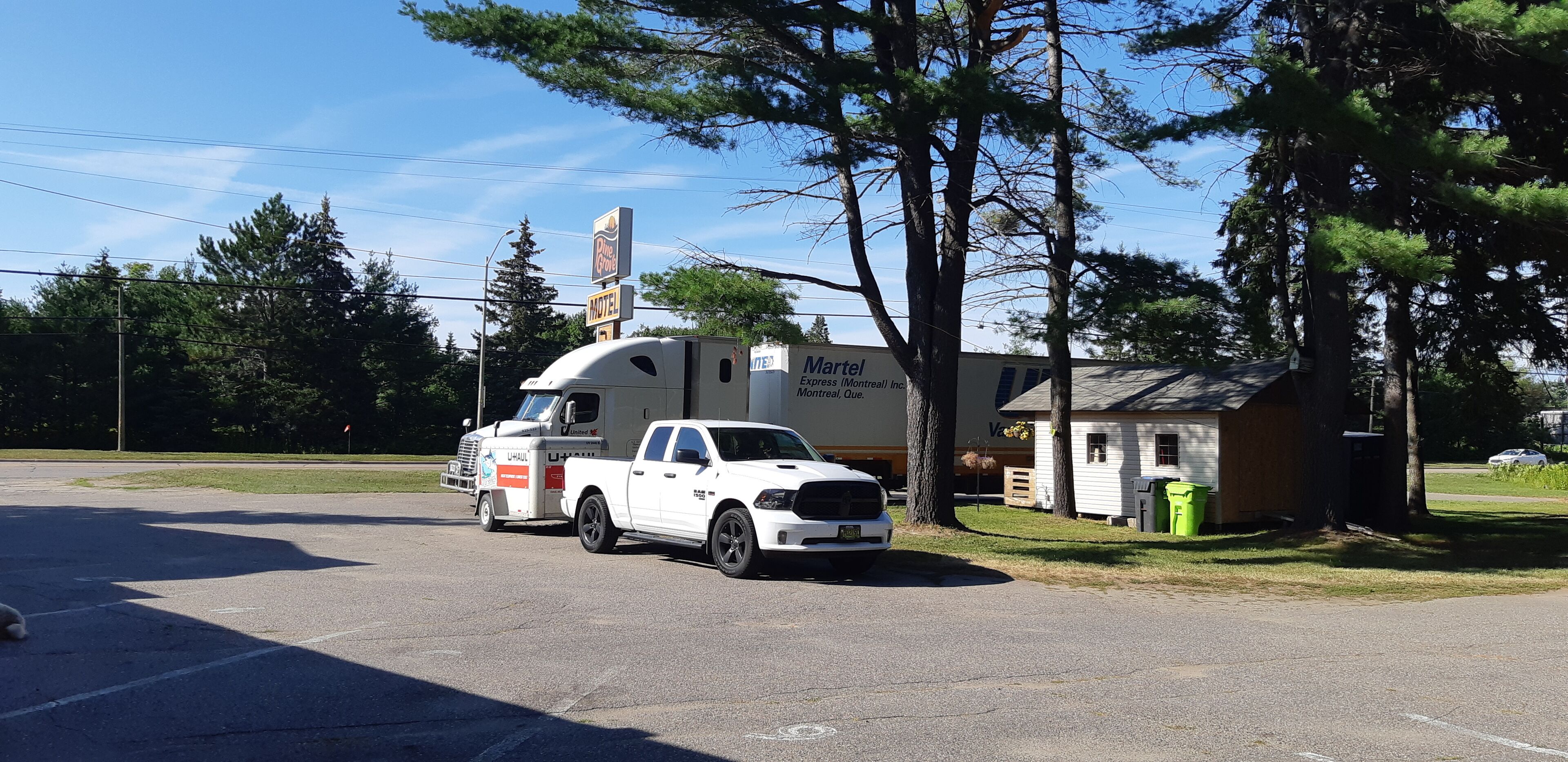 Uma caminhonete branca estacionada em frente a um edifício com uma placa que diz 'Martel Express Montreal Inc.'