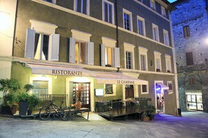 Restaurante chamado "Ristorante Le Campane" com área externa e uma bicicleta estacionada na frente.