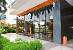 Uma cafeteria moderna com fachada de vidro, detalhes em madeira e um logotipo no toldo.