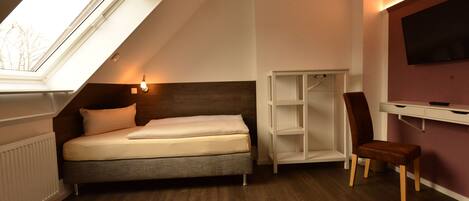 Quarto com cama, escrivaninha, cadeira e guarda-roupa.