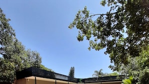 Um edifício moderno com piscina, um espaço coberto de varanda e um gramado bem cuidado.