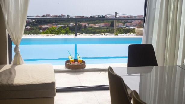 Varanda com vista para uma piscina e paisagem distante.