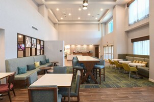 Um hall amplo com área de estar, balcão de recepção e bar.