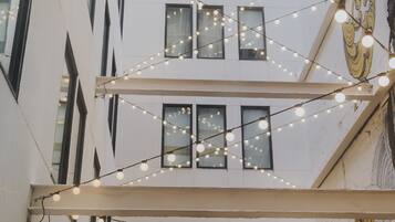 Um edifício de vários andares com luzes de corda penduradas entre os pisos.