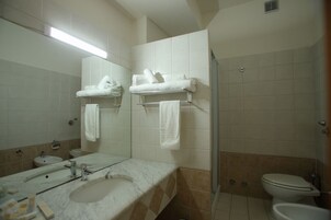 Casa de banho com lavatório, espelho, porta-toalhas e sanita.