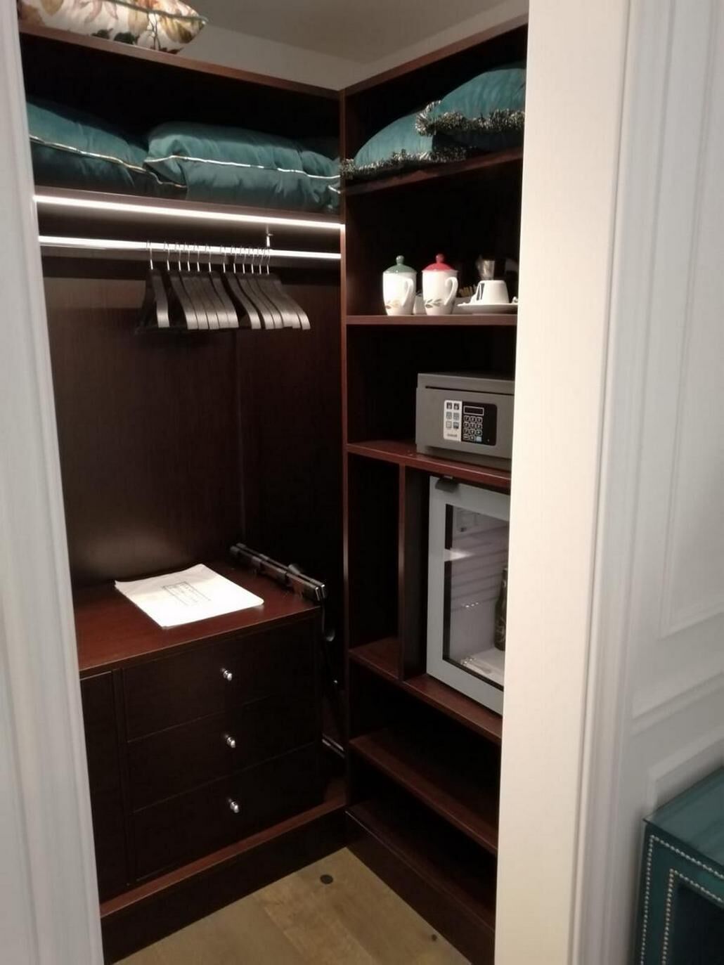 Um closet espaçoso com cabideiro, prateleiras e gavetas.