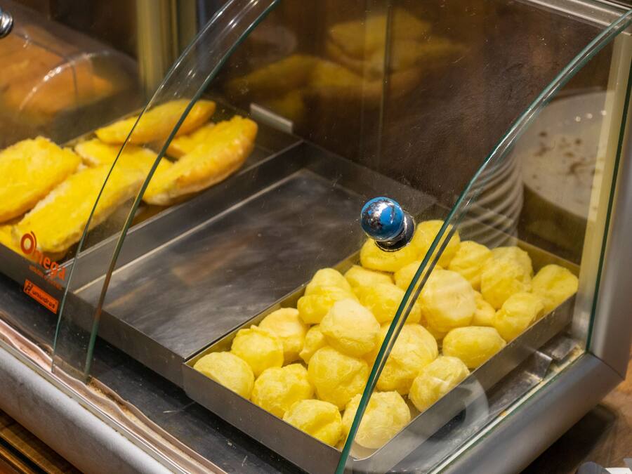 Buffet com vitrine de vidro contendo diversos alimentos.