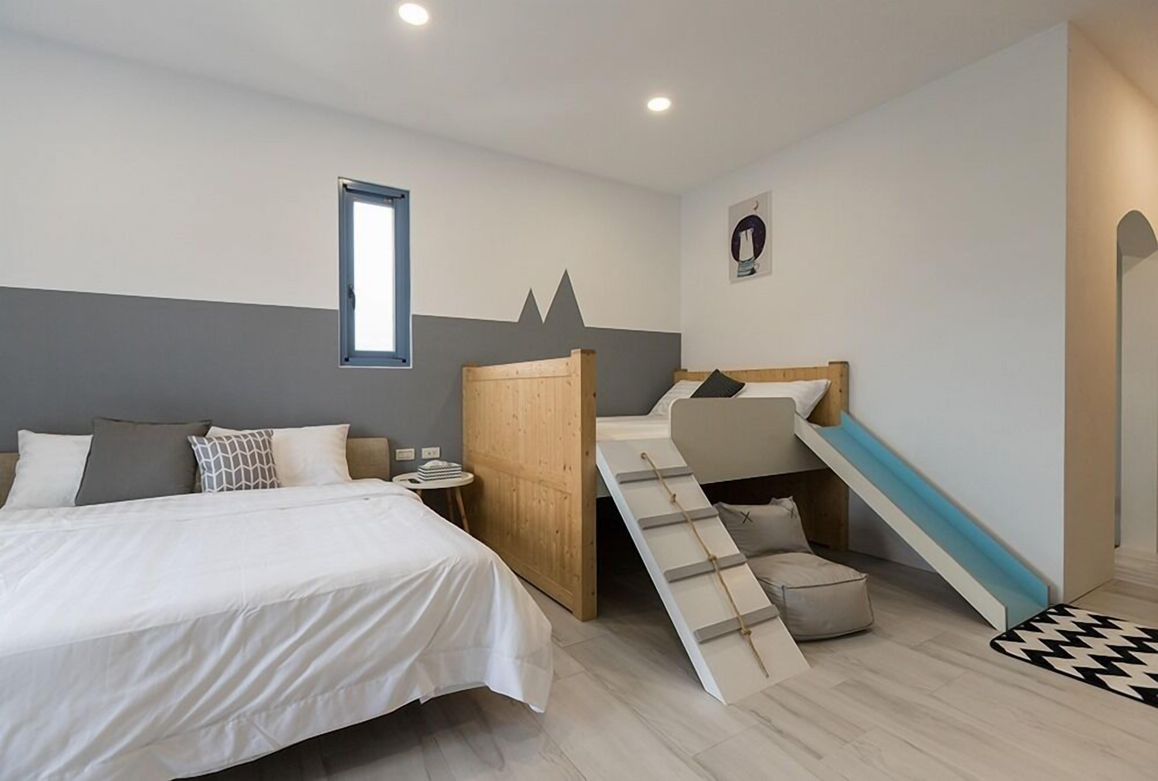 Um quarto com cama, escrivaninha, janela e beliche.