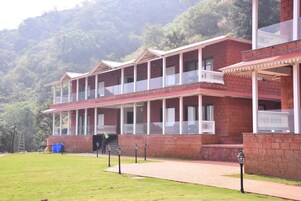 Um edifício de vários andares com fachada de tijolos vermelhos, varandas e uma galeria coberta.
