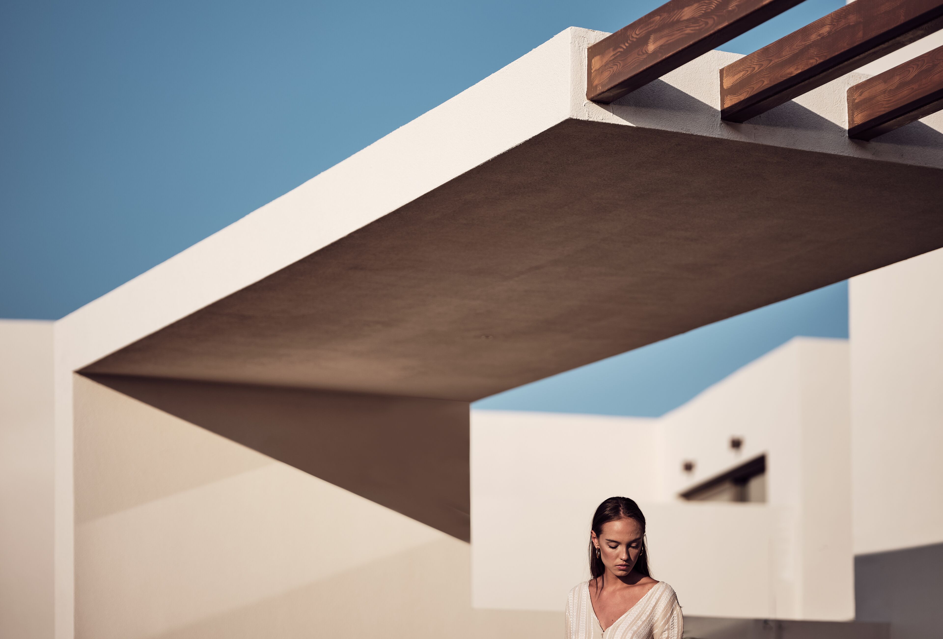 Uma estrutura arquitetônica moderna com design geométrico, apresentando um largo beiral e fachada branca.