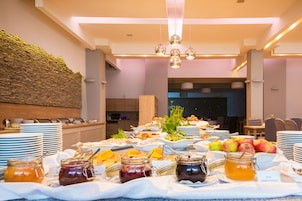 Uma mesa de buffet com diversos alimentos e acompanhamentos.