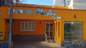 Um edifício amarelo com uma placa que diz "HOTEL Pacha" e "ANEXO" na fachada.