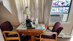 Uma mesa de jantar com uma cafeteira, uma caixa de lenços e um tabuleiro com uma revista.