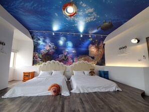 Quarto com duas camas, um mural de cena subaquática, uma luminária no teto e aquecedor fixado na parede.