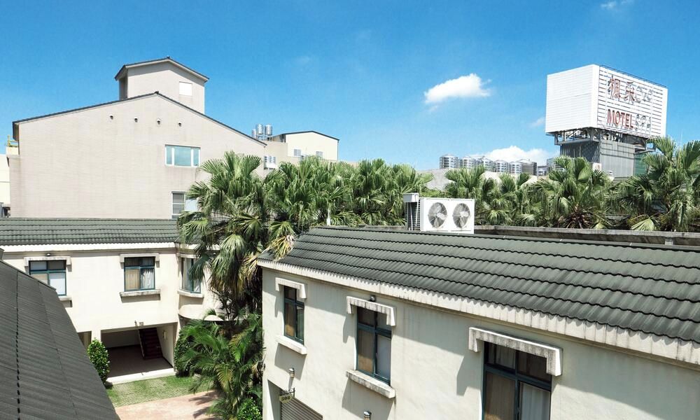Área residencial com edifícios modernos, incluindo um motel com uma grande placa.