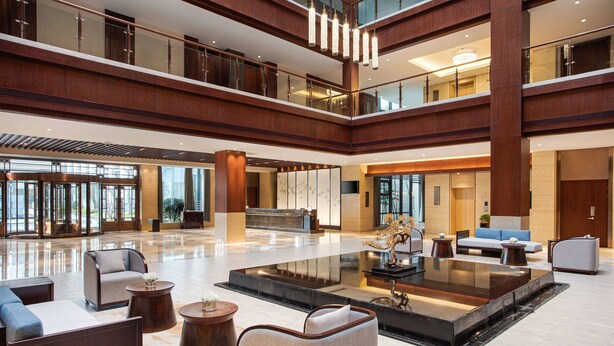 Um hall amplo com uma mesa de centro, área de estar e balcão de recepção.