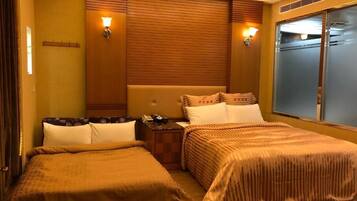 Quarto de hotel com duas camas, cabeceira de madeira, luminárias laterais, mesa de cabeceira e janela com vidro jateado.