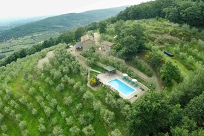 Uma vila isolada com piscina, rodeada por vegetação exuberante e campos em socalcos.