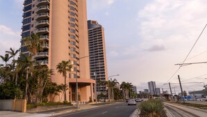 Um edifício alto e moderno com várias varandas e um design curvo.