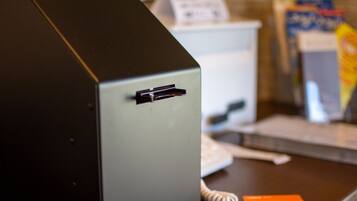 Visão detalhada de um monitor de computador com uma entrada USB, leitor de cartão e um telefone sobre a mesa.