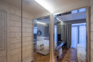 Quarto de hotel moderno com uma cama grande, uma escrivaninha e um espaço de estar.