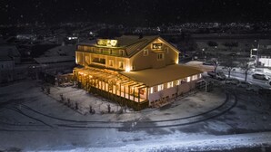 Um edifício de dois andares com uma placa no telhado que diz "KUNST", cercado por neve.