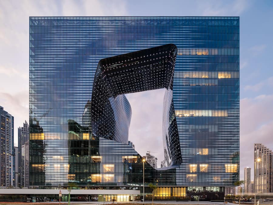Um edifício moderno de vidro com fachada curva e singular.