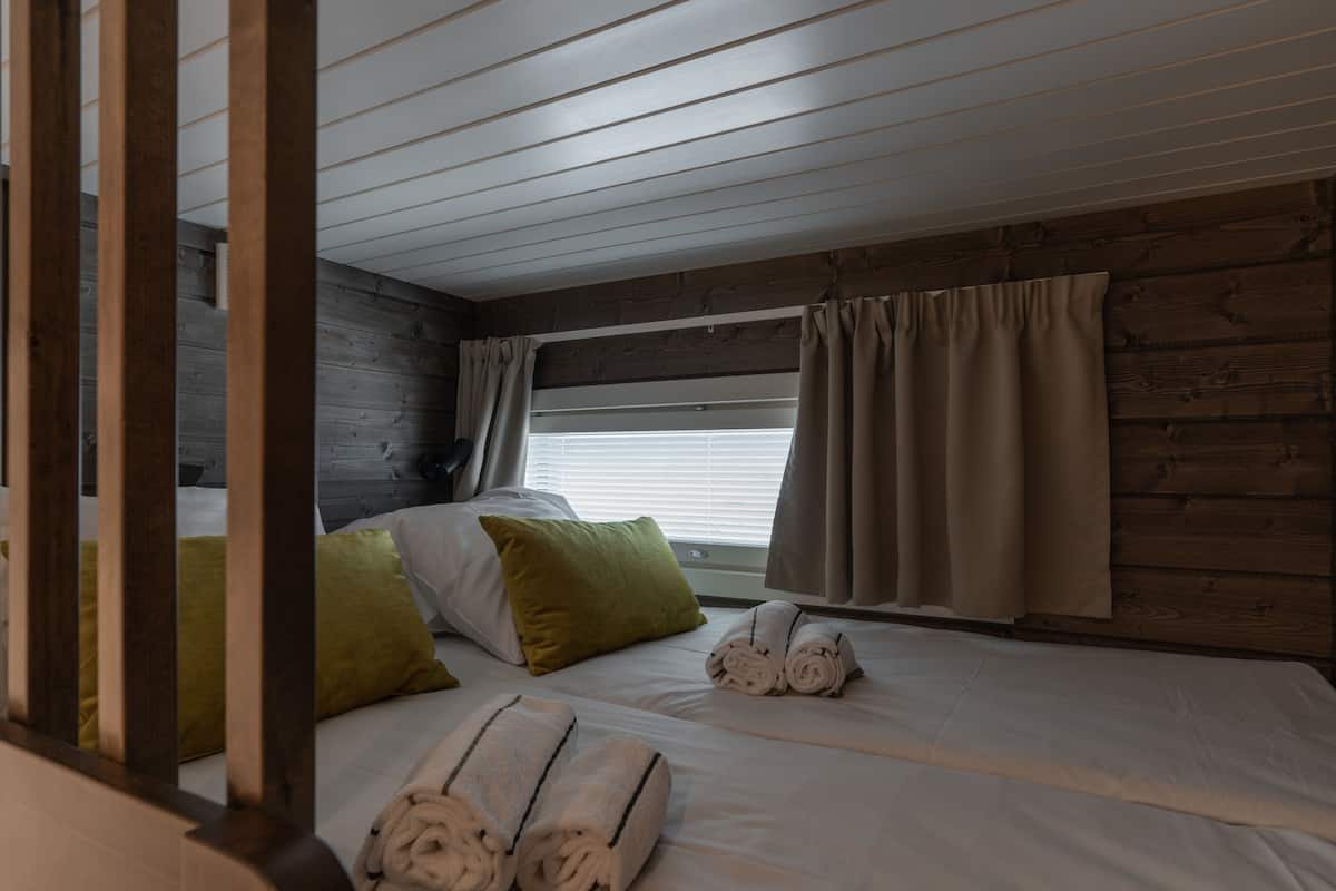 Quarto com cama, almofadas e toalhas dobradas.