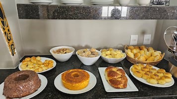 Buffet com diversos produtos de panificação e pastelaria à mostra.