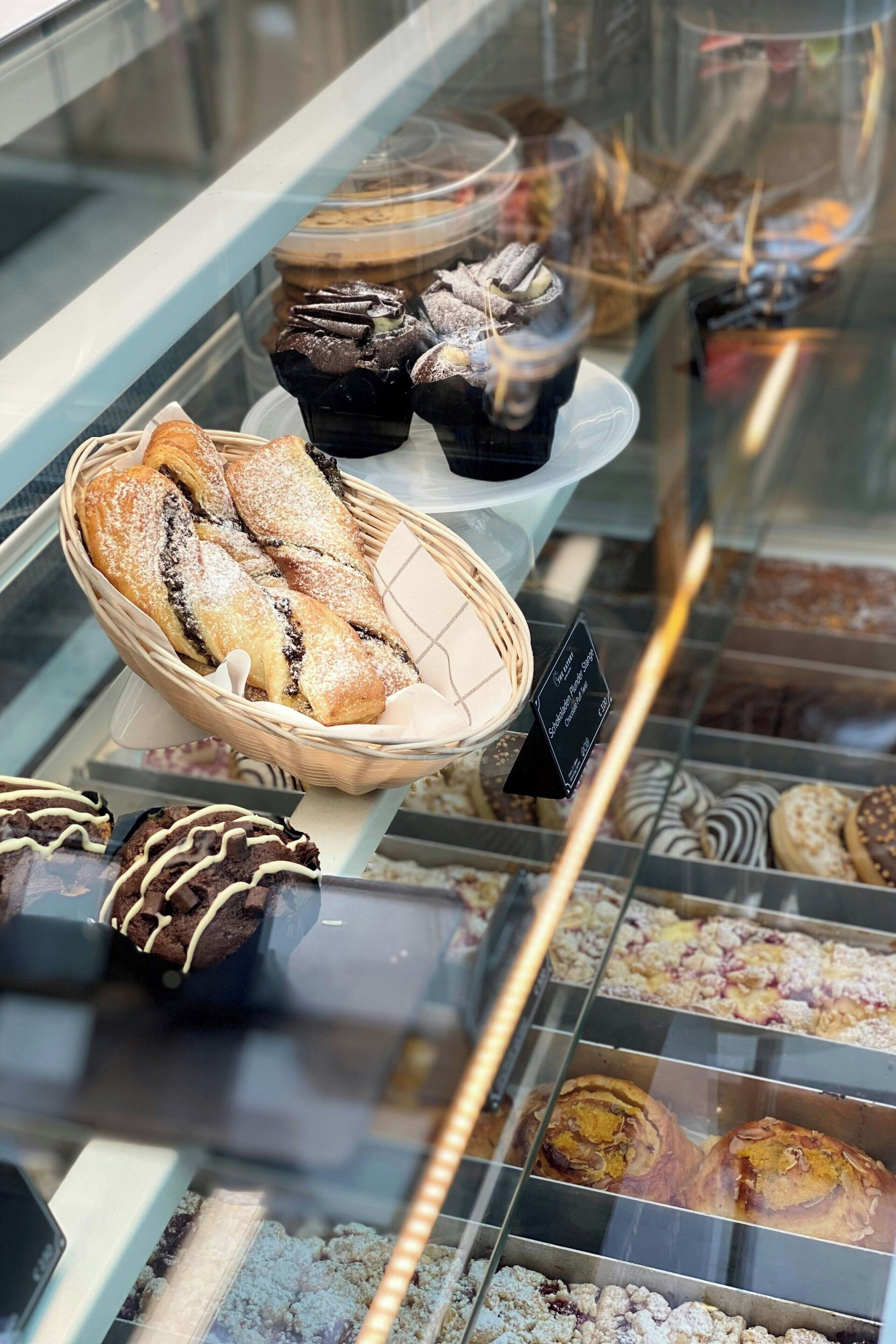 Vitrine de pastelaria com diversos doces e produtos de pastelaria.