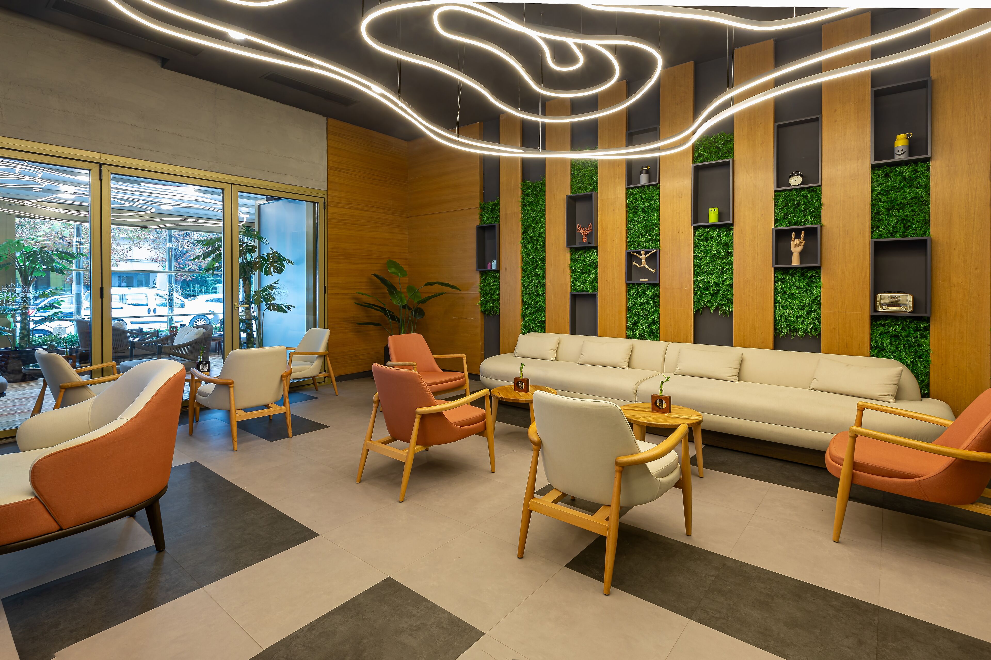 Um interior moderno com um sofá, cadeiras e uma parede verde com prateleiras.
