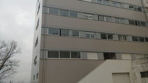 Um edifício de vários andares com fachada em azulejos e várias janelas.