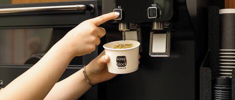 Alguém usando uma máquina de café para encher uma xícara.