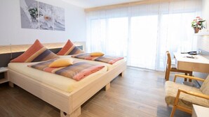 Quarto moderno com cama de madeira, uma escrivaninha e uma cadeira.