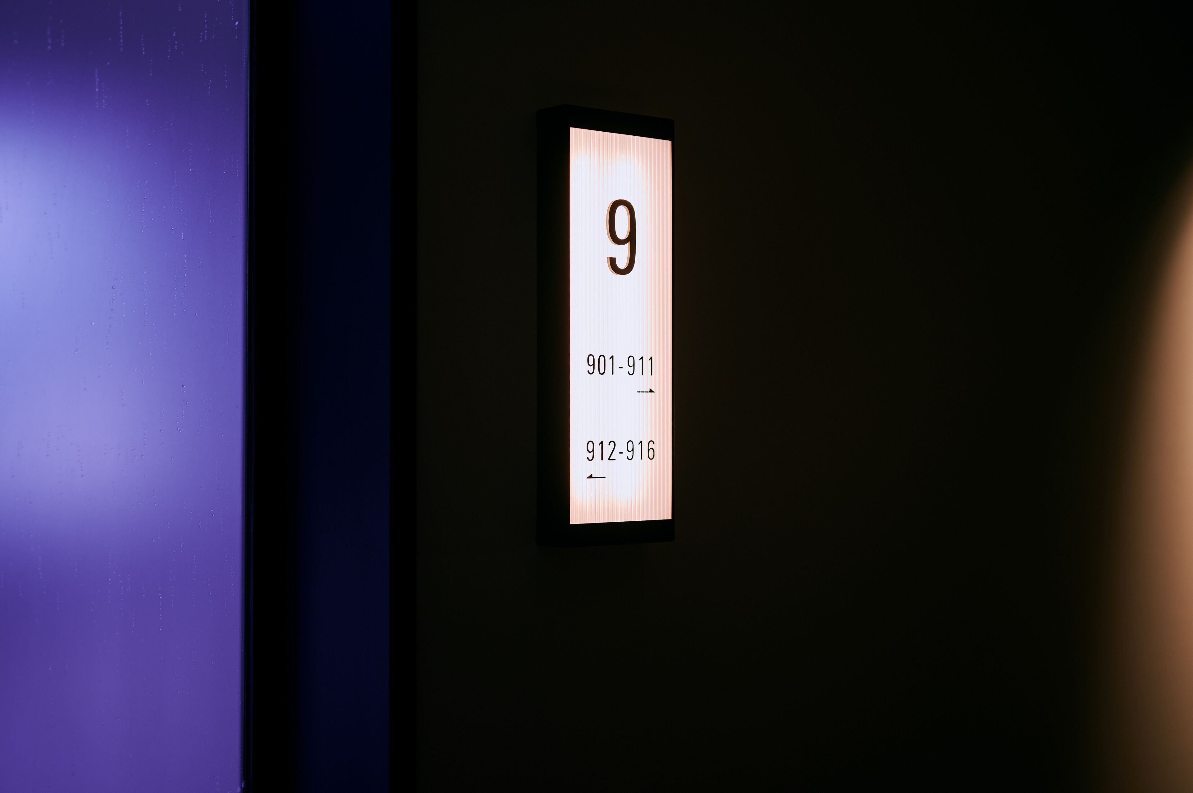 Placa na parede com o número 9 e dois números de telefone.
