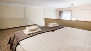 Quarto de hotel com cama, janela com cortinas e luminária no teto.
