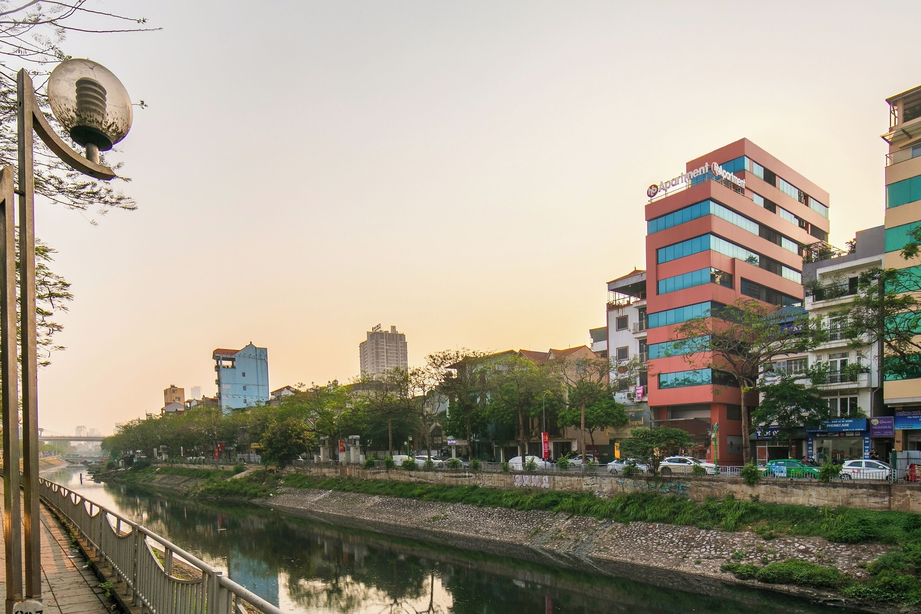Vista do rio de uma cidade com edifícios modernos, incluindo um complexo de apartamentos.