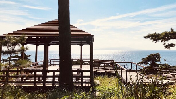 Um gazebo de madeira com vista para o mar.