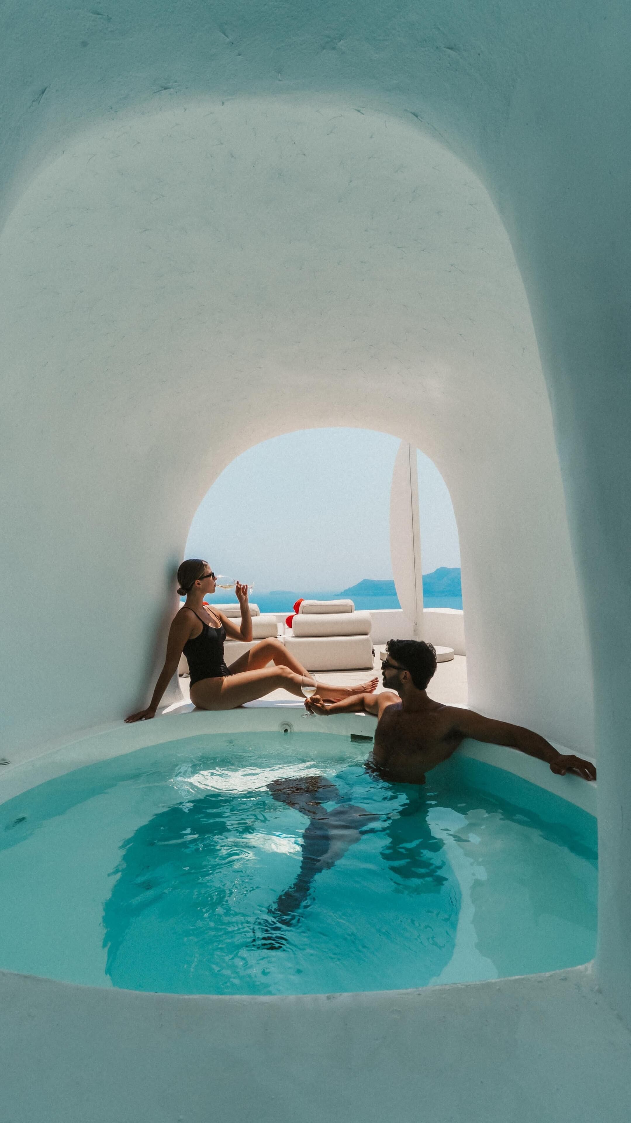 Uma área de piscina privativa com vista clara para o mar e montanhas ao fundo.