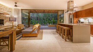 Uma cozinha moderna com uma ilha central, banquetes de madeira e uma parede de pedra.