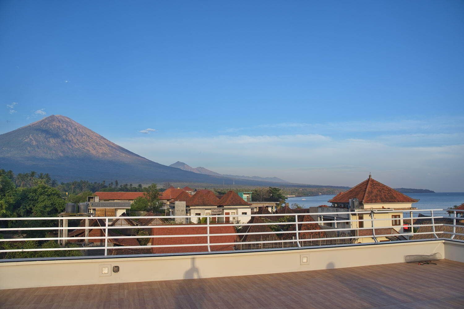 Vista de uma varanda com vista para uma cidade, com uma montanha ao fundo.