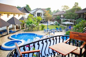 Um hotel com piscina, área de estar externa e vista para a região ao redor.