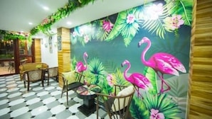 Um quarto com piso xadrez, um mural de flamingos cor-de-rosa e uma parede de madeira.