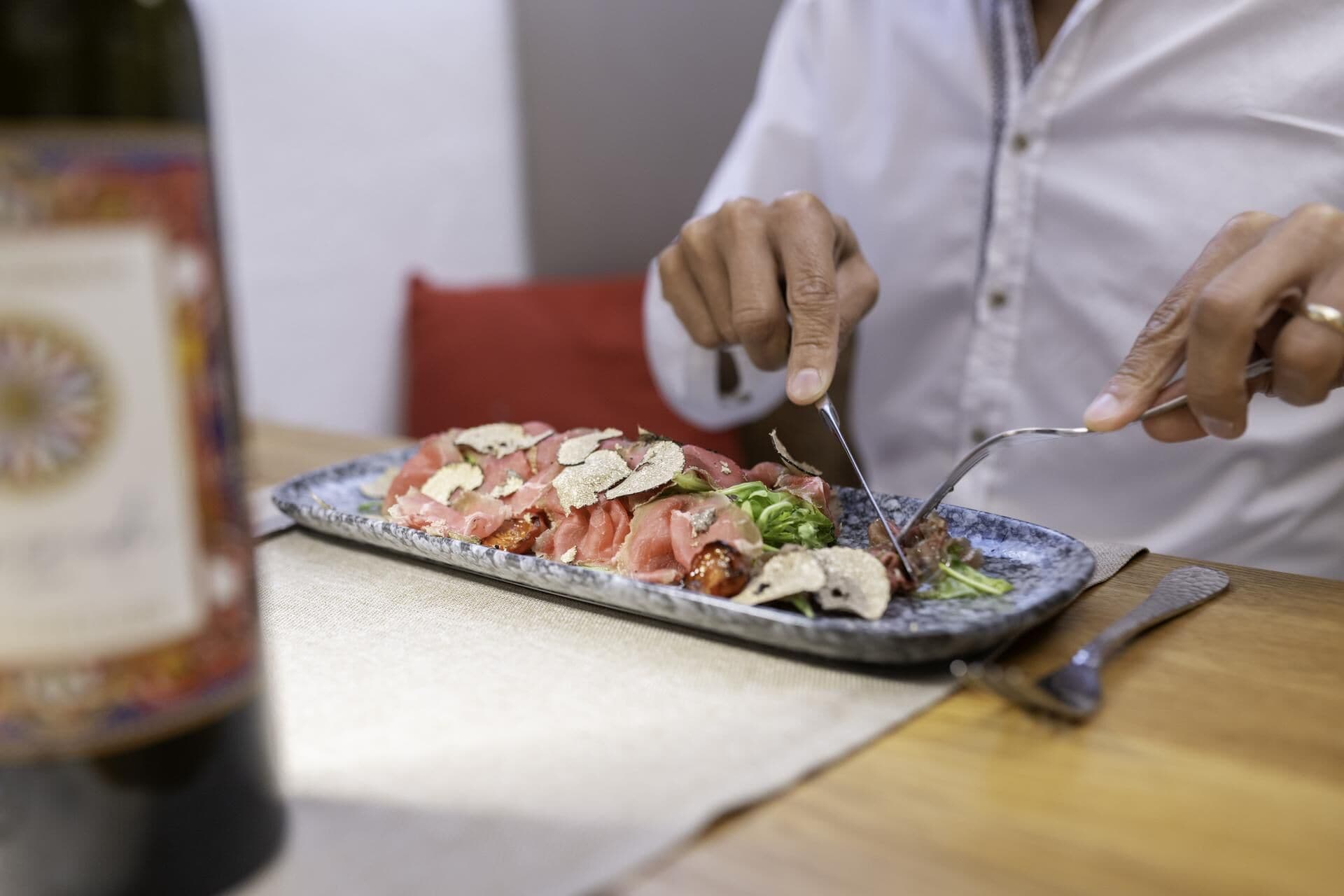 Alguém servindo um prato em uma travessa de cerâmica.