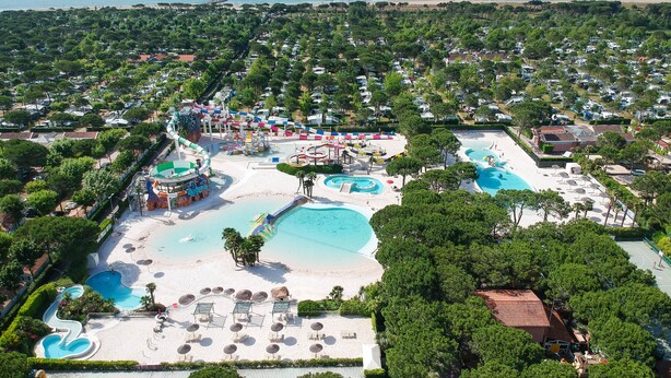 Vista aérea de um resort com várias piscinas, parque aquático e área de praia.