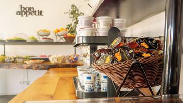 Uma área de buffet com diversas opções de comida e acompanhamentos.