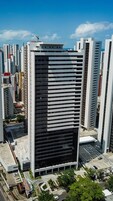 Um edifício moderno de vários andares com fachada singular, caracterizada por ripas horizontais.
