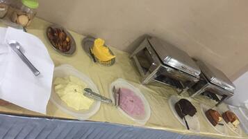 Uma mesa de buffet com diversos pratos, incluindo um amarelo, um com substância rosa e vários outros.