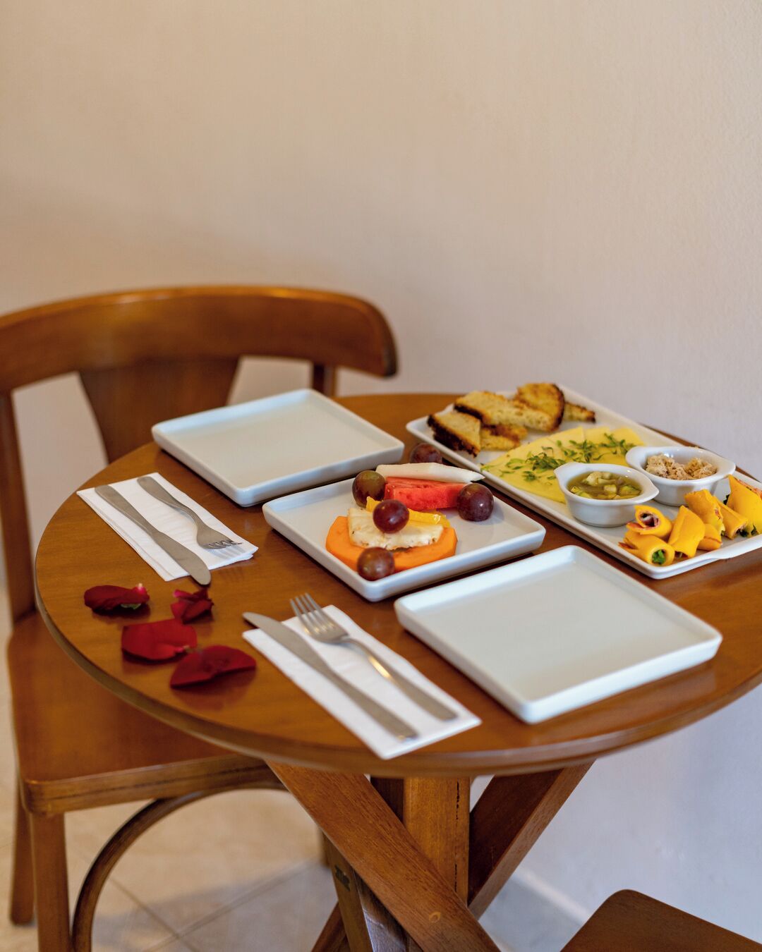 Uma mesa de jantar com pratos de comida, talheres e guardanapos.