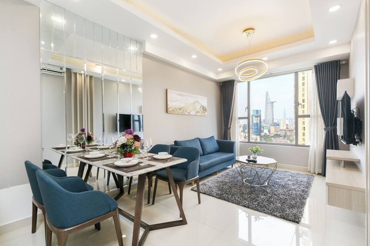 Uma sala de estar moderna com área de jantar, um sofá e vista para a cidade.
